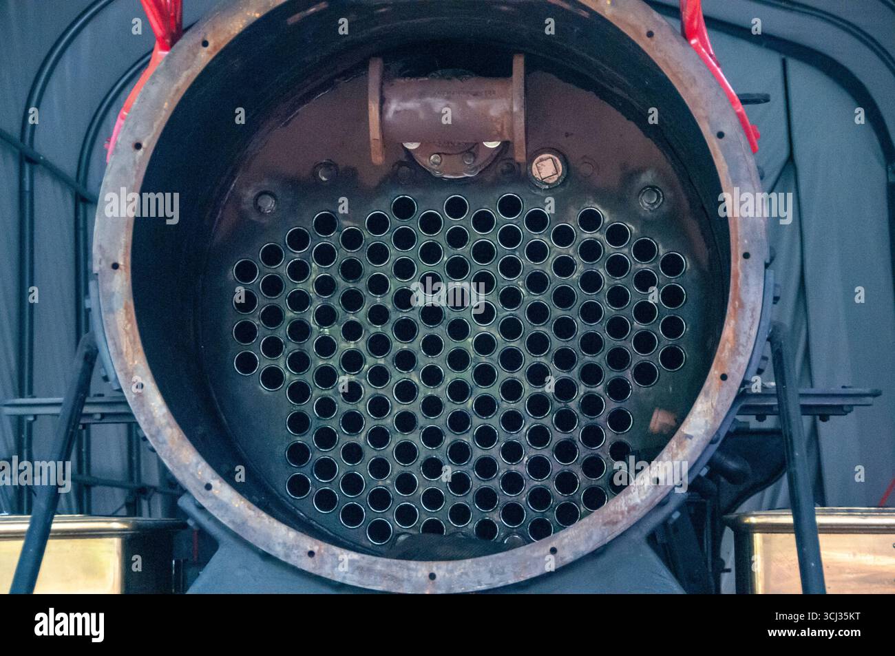 The interior of a steam locomotive's boiler reveals a network of tubes ...