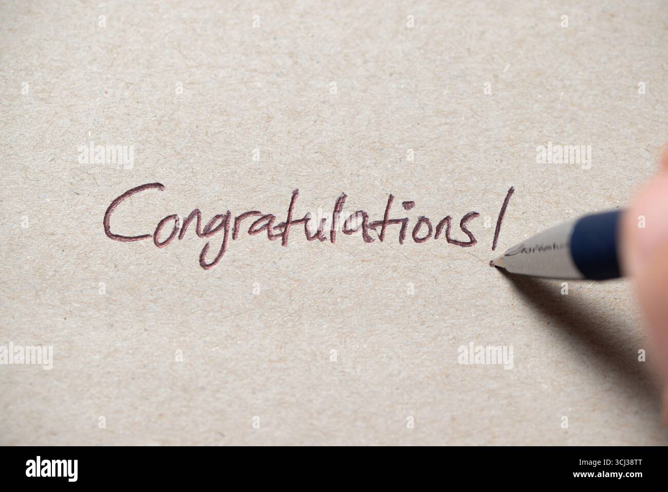 A close-up of a handwritten Congratulations written in ink on paper ...