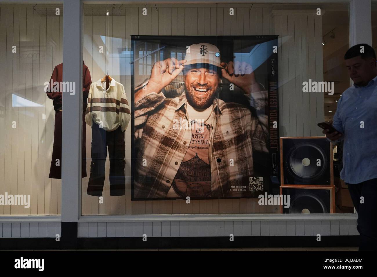 A shopper walks by an ad featuring Kansas City Chiefs' Travis Kelce ...