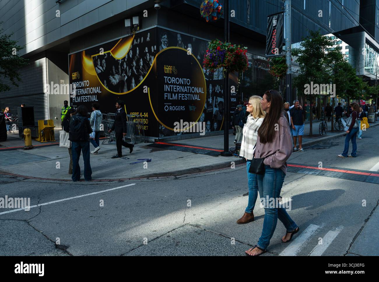 People walk by a TIFF sign at the Toronto International Film Festival ...