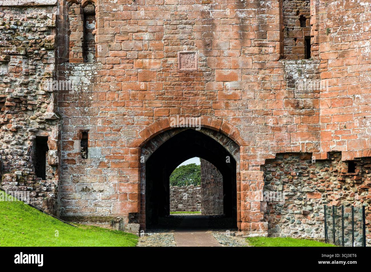 Weathered red sandstone walls of the medieval gatehouse at Brougham ...