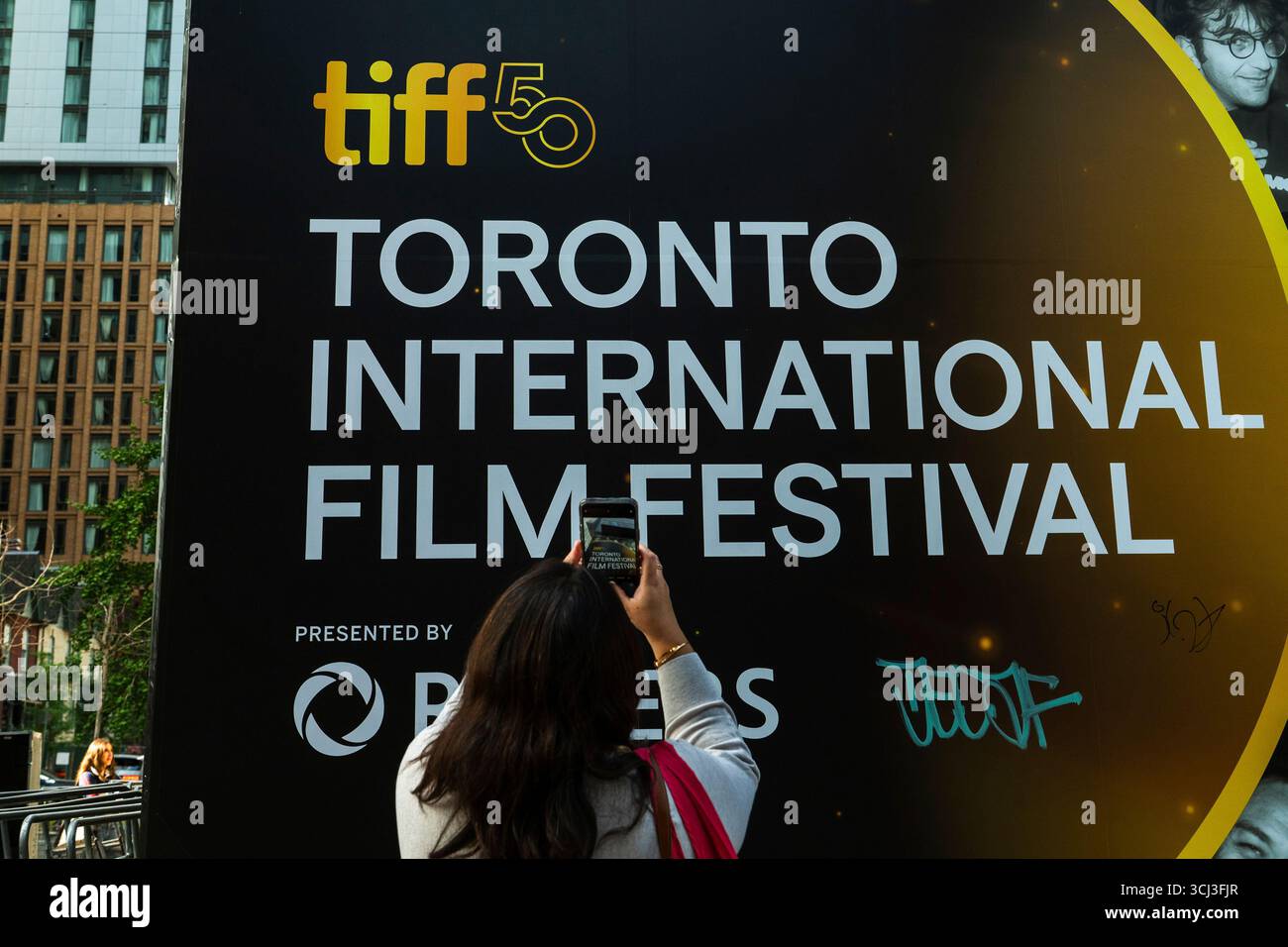 A woman takes a photo of a TIFF sign at the Toronto International Film ...