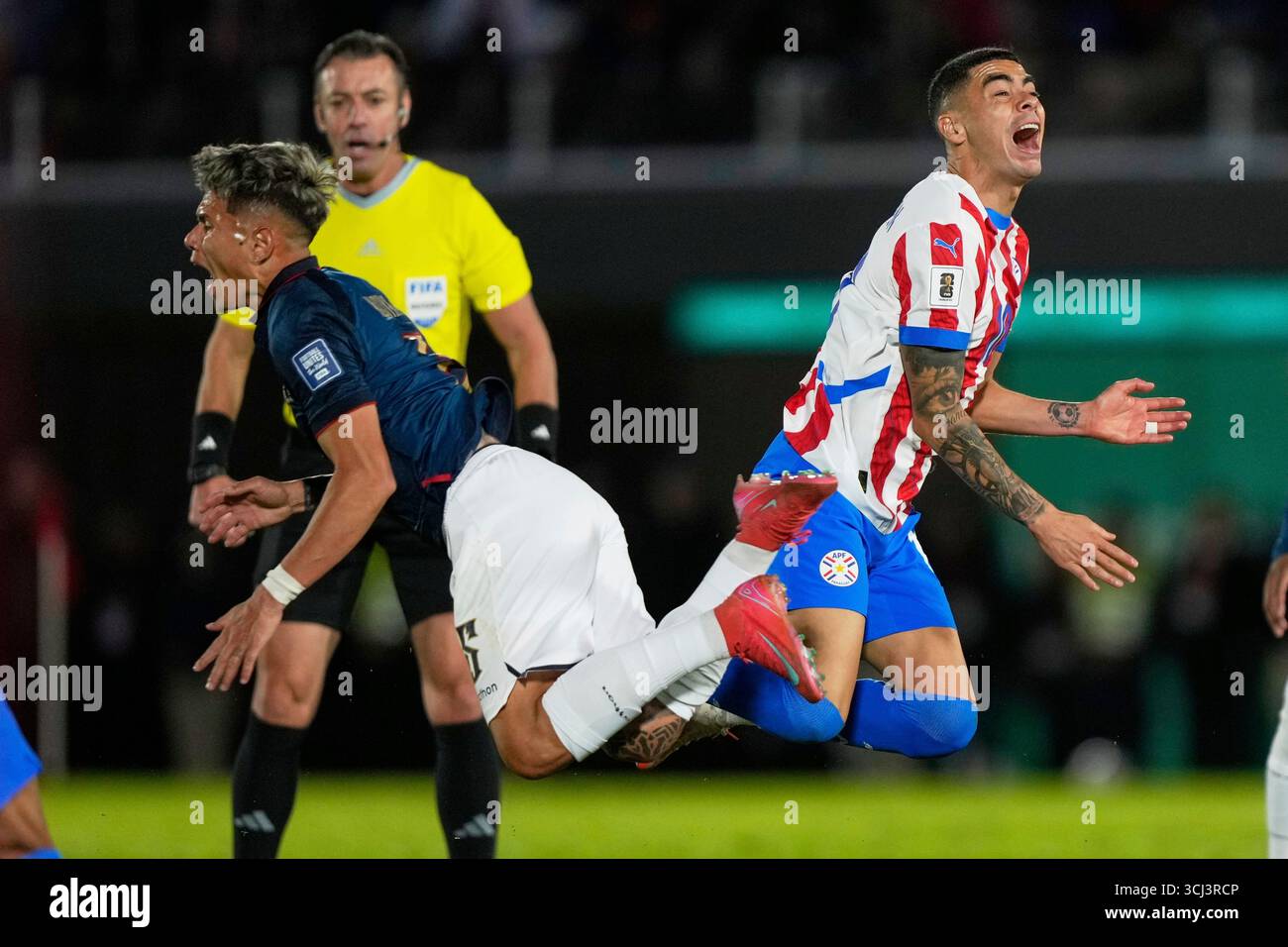 Ecuador's Jordy Alcivar, left, and Paraguay's Miguel Almiron fall over ...