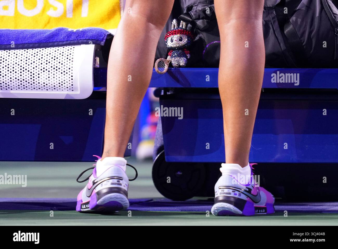 A Labubu doll is seen between the legs of Naomi Osaka, of Japan, during ...
