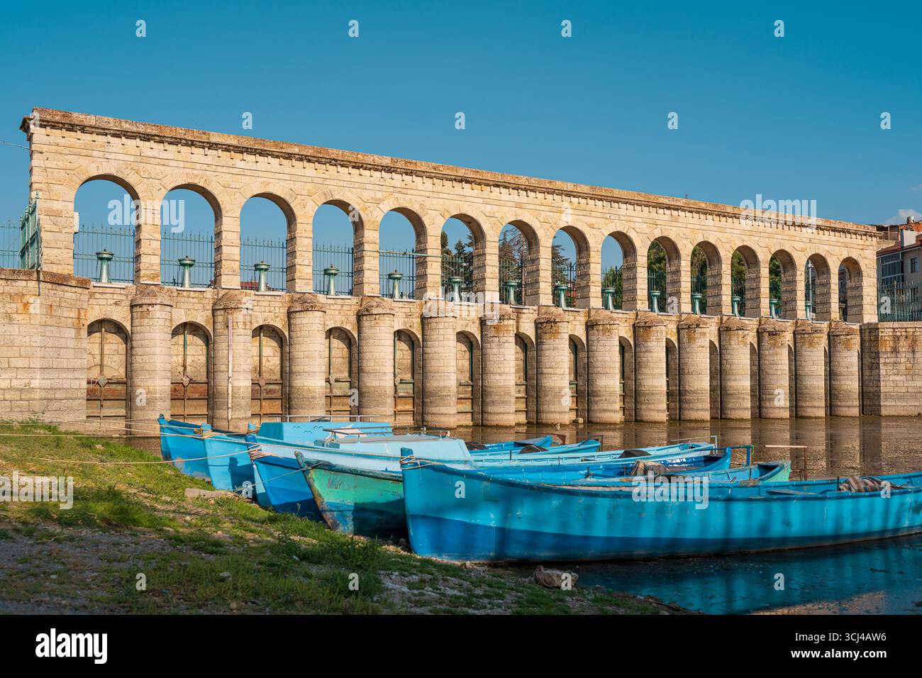 Historic Beysehir Stone Bridge with blue boats on lake Stock Photo - Alamy