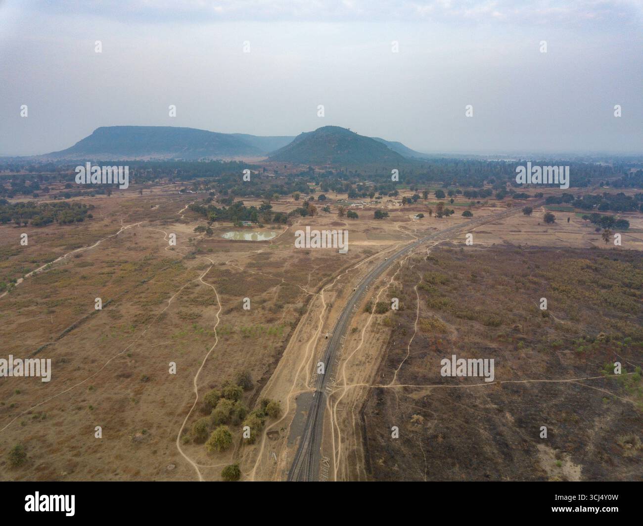 Aerial view of a long road cutting through the arid landscape towards ...