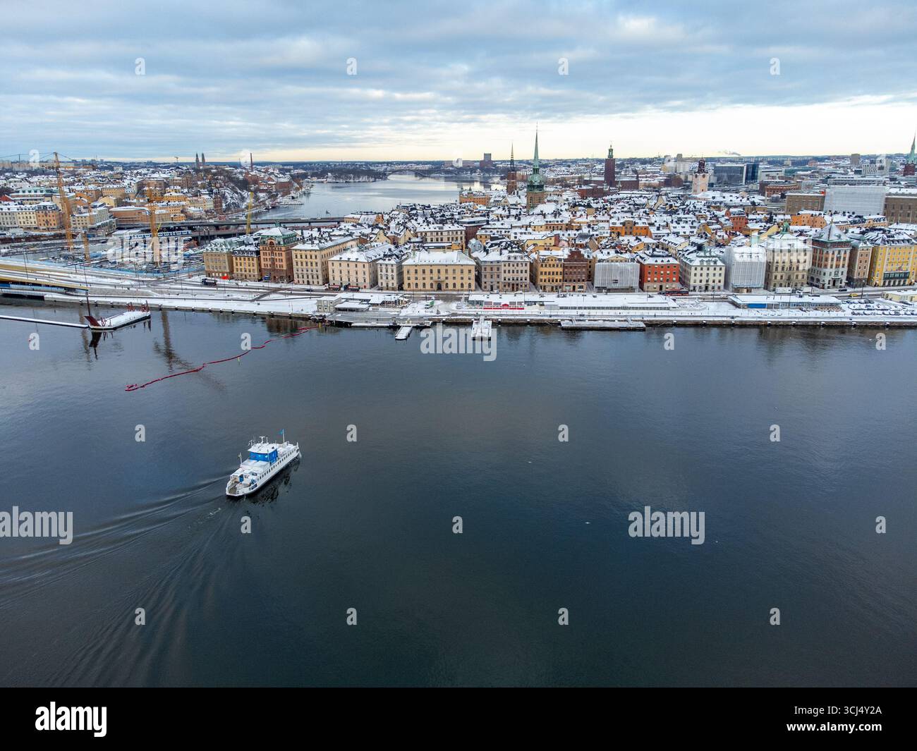 Aerial view of a ferry cutting through the dark waters, juxtaposed ...