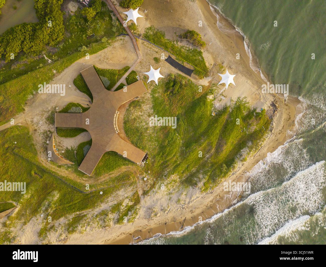 Aerial view of the geometric building meets the sandy shore, where the ...
