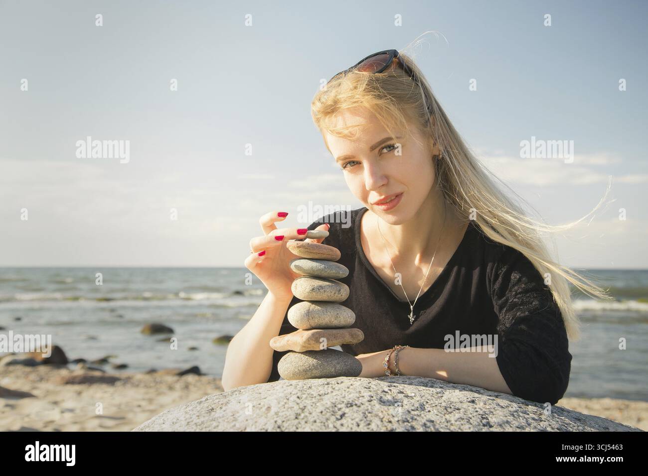 Beautiful woman stacking stones hi-res stock photography and images - Alamy