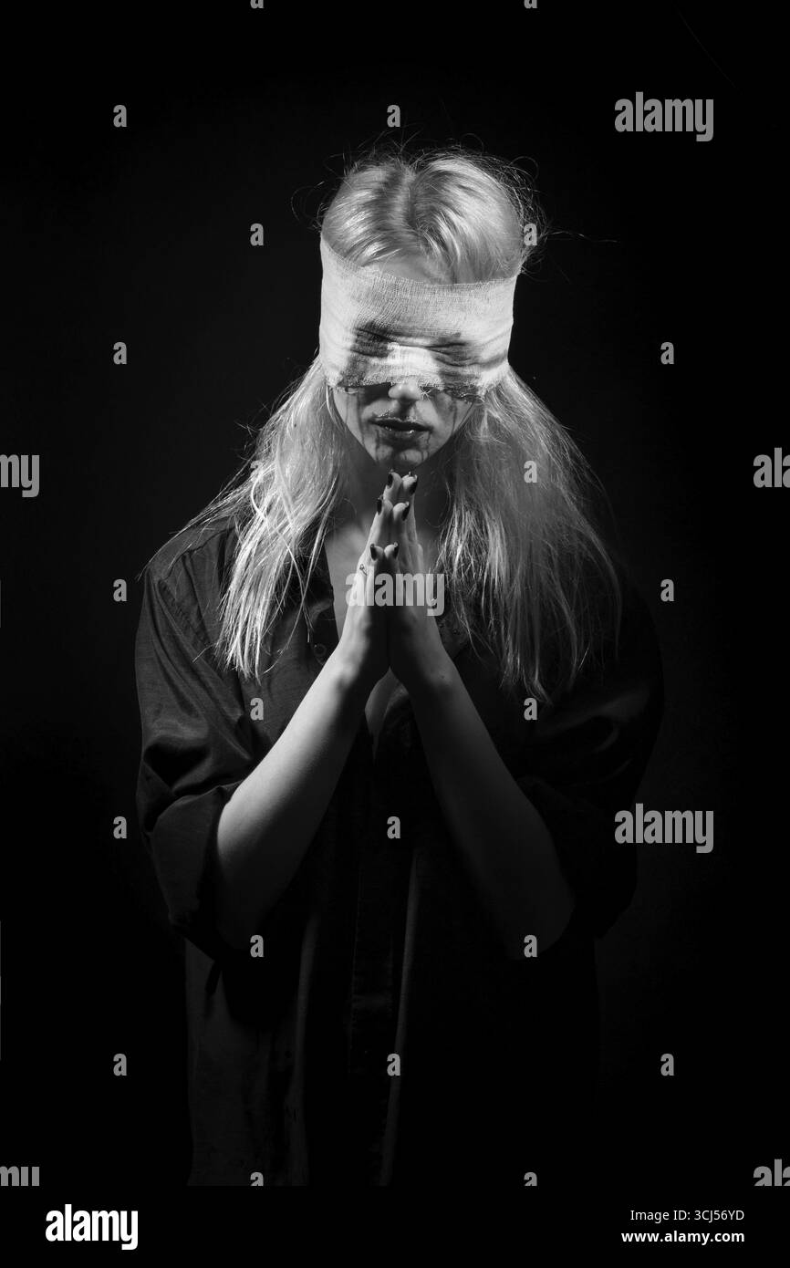 Sad blooded woman on black background praying, monochrome Stock Photo ...