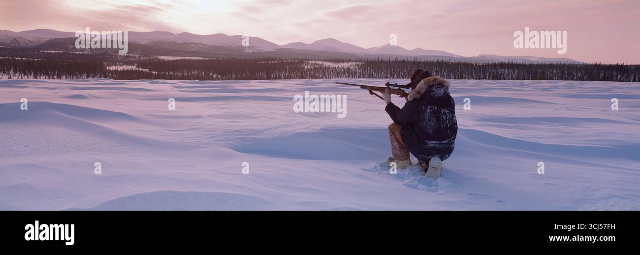 Male hunter aiming a high-powered rifle in Alaska's remote Arctic ...