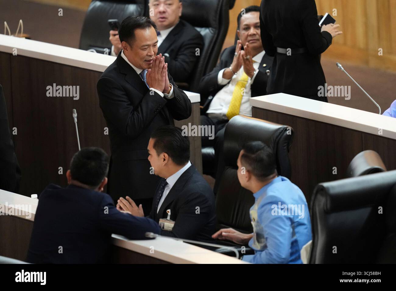 Leader of Bhumjai Thai Party Anutin Charnvirakul, center, reacts after Lawmakers vote to select ...