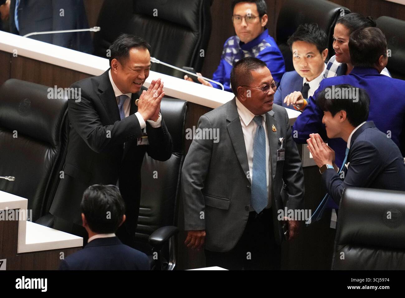 Leader of Bhumjai Thai Party Anutin Charnvirakul, left, reacts after lawmakers voted to select ...