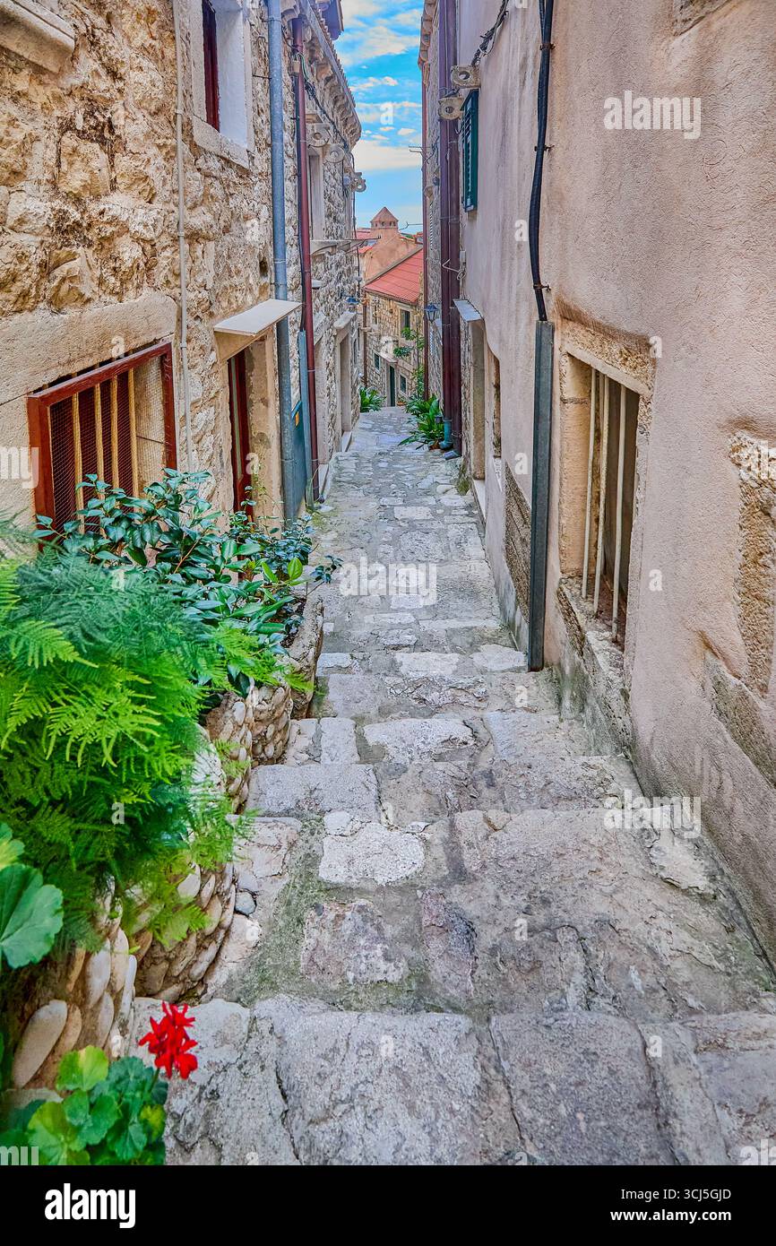 Rising stone steps in narrow alley walkways between old town buildings ...