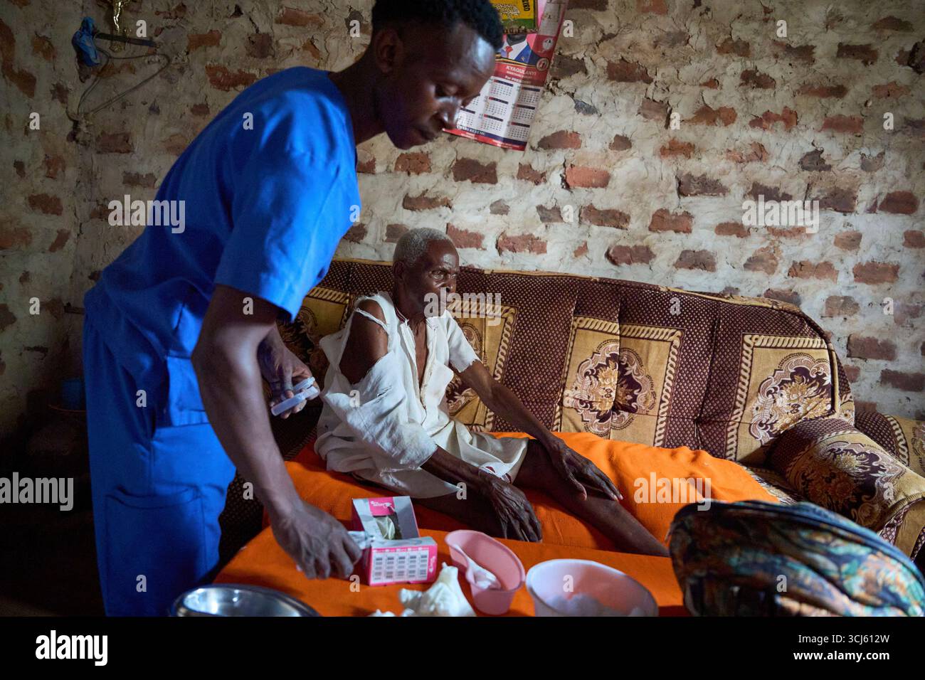 Yafesi Nakyanga, 86, sits up after having his catheter changed by field ...