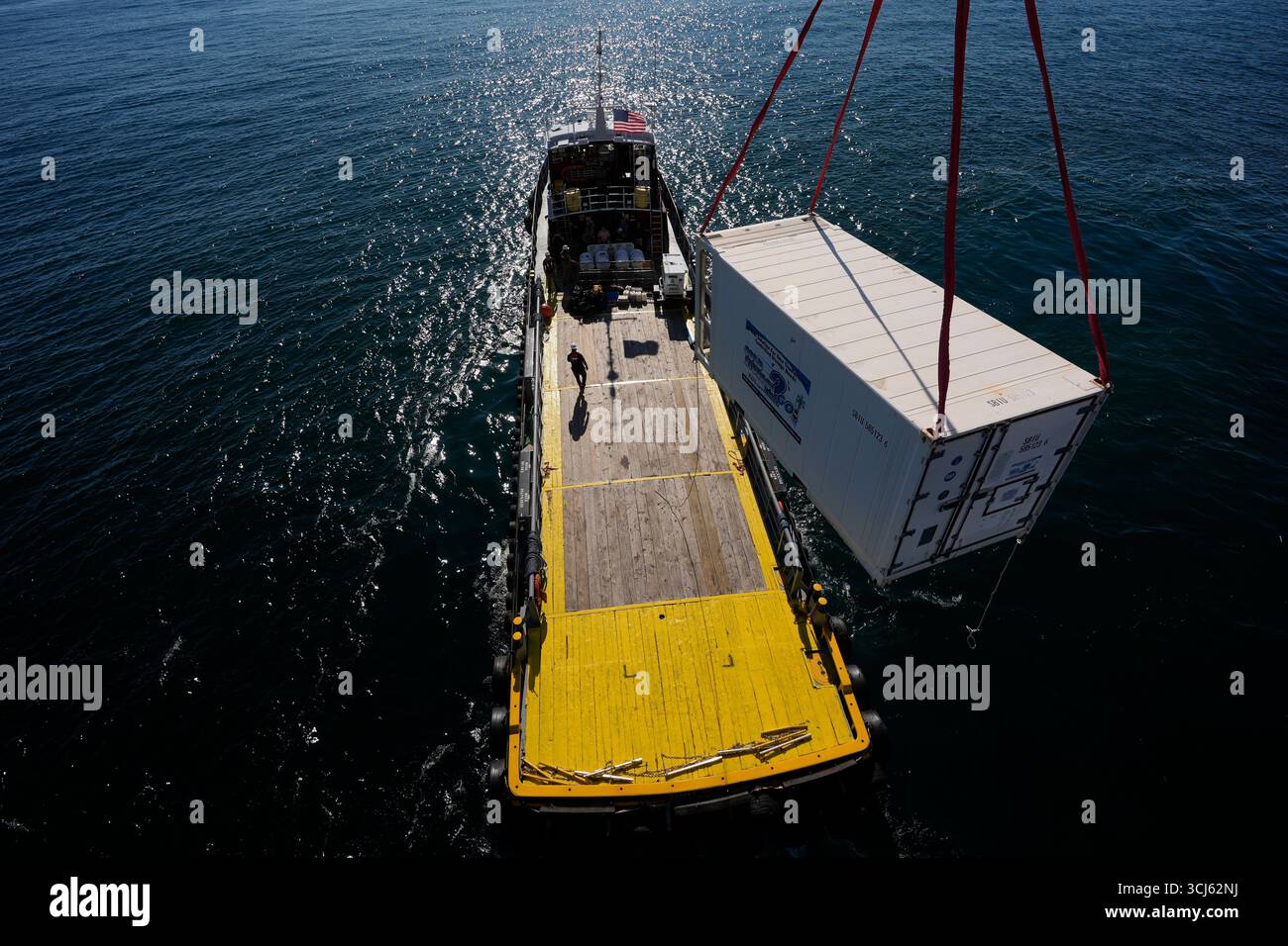 A supply container is lifted from the Gaspee, a crew transport vessel ...