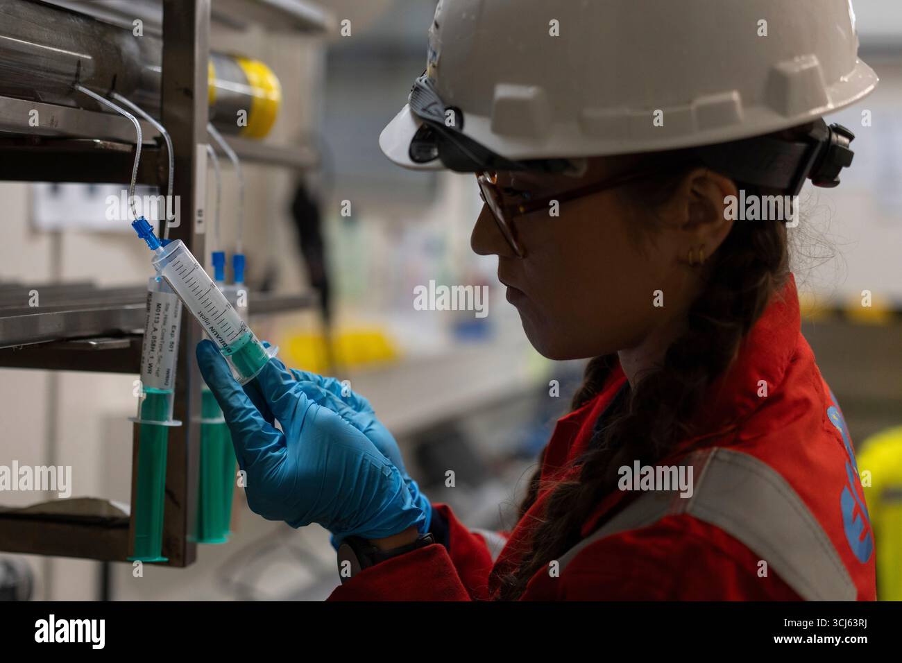 Expedition 501 researcher Alizé Longeau collects water samples from ...