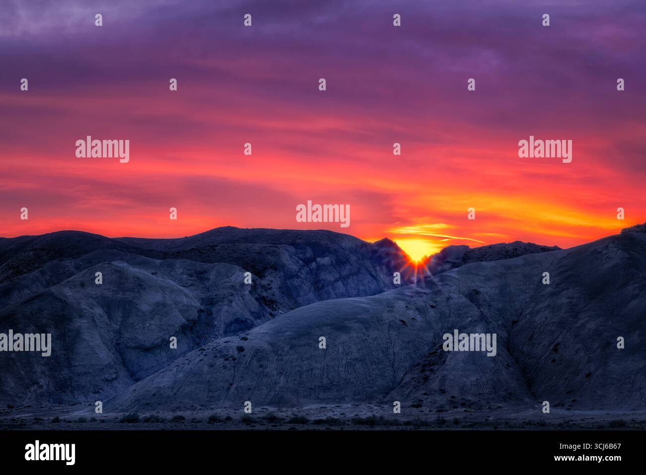 Bentonite Hills UT - The sun sets behind the hills along Cathedral ...