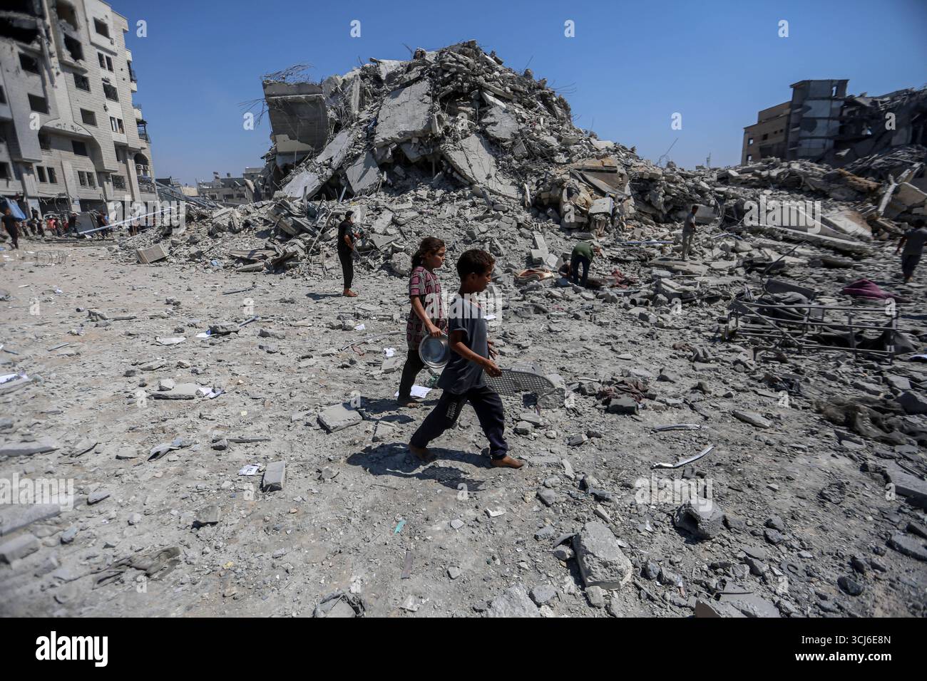 Palestinians check the debris of the Mushtaha Tower in Gaza City ...