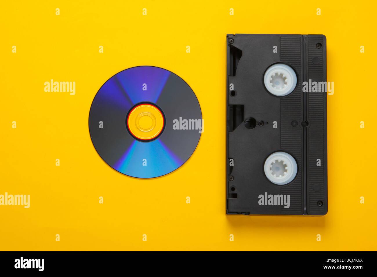 Flat lay composition of cd disc, audio cassette on a yellow background ...