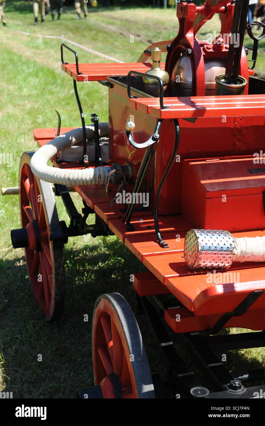Rear detail of a historic horse-drawn fire pump with hose and metal ...
