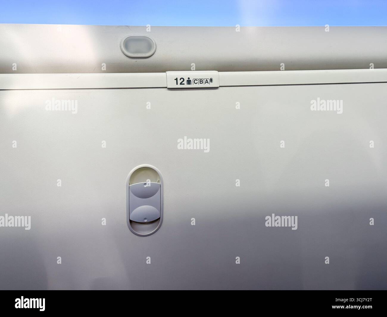 Closed overhead locker inside airplane cabin with seat number label ...