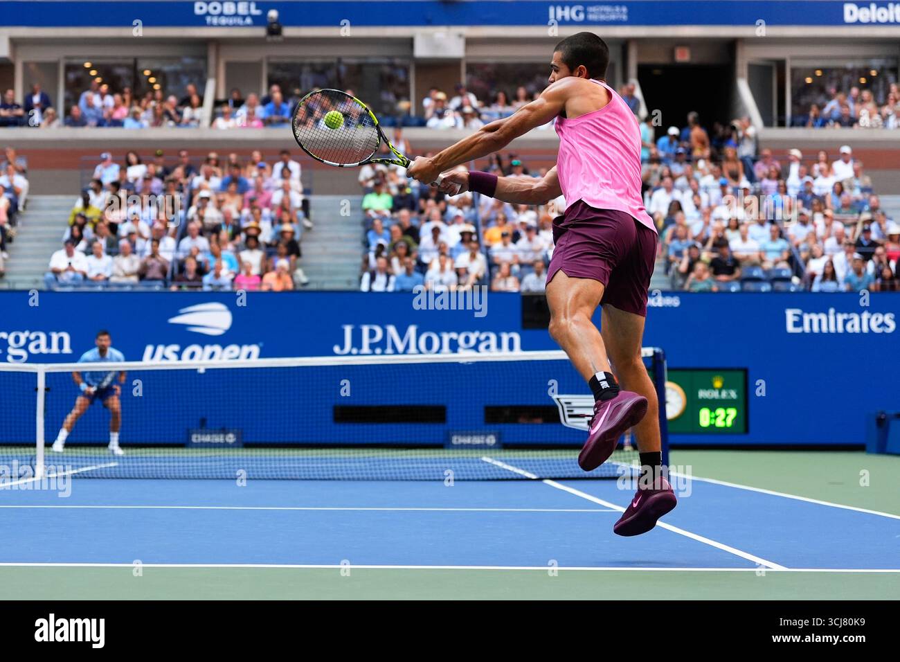 Carlos Alcaraz, of Spain, returns a shot to Novak Djokovic, of Serbia, during the men's singles ...