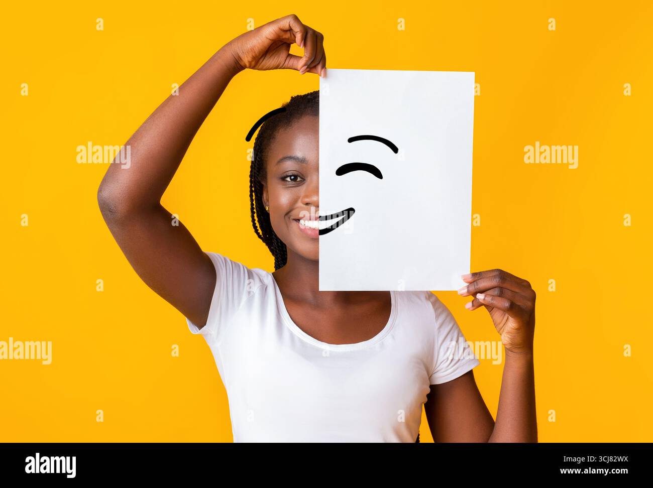 Black woman covering half face with smiley picture Stock Photo - Alamy
