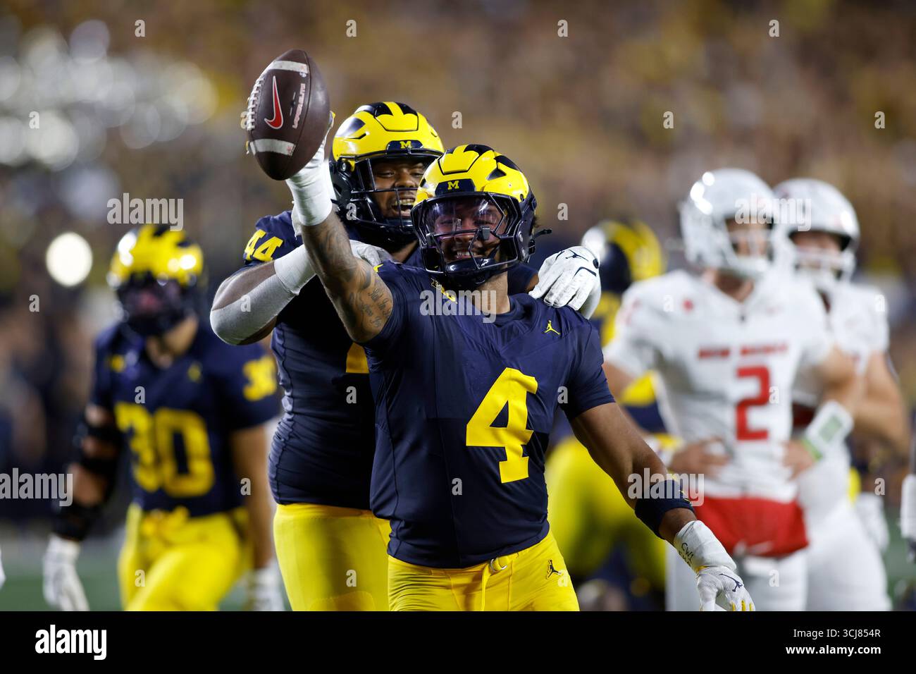 Michigan edge TJ Guy (4) and defensive lineman Damon Payne (44 ...