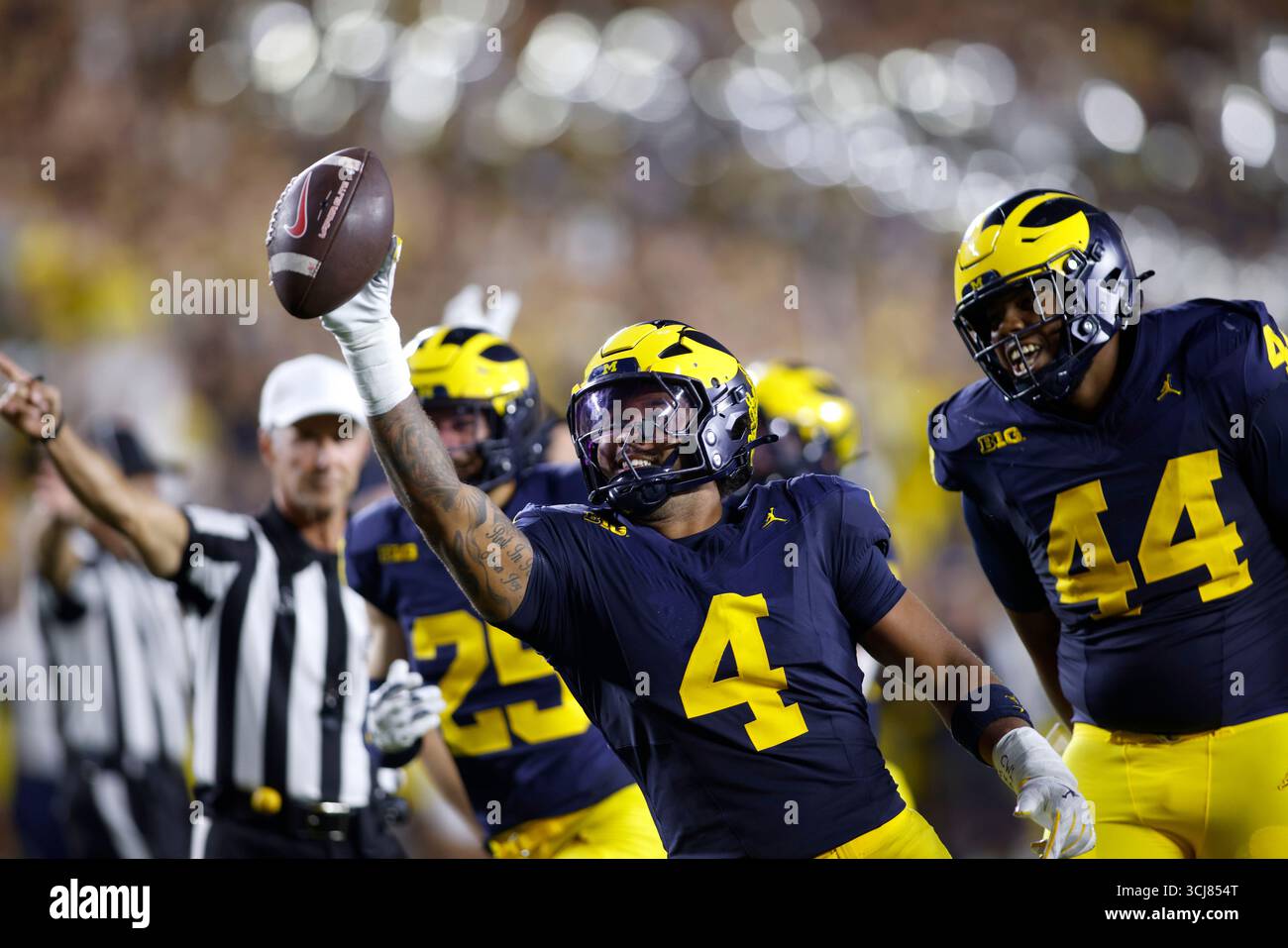 Michigan edge TJ Guy (4) and defensive lineman Damon Payne (44 ...