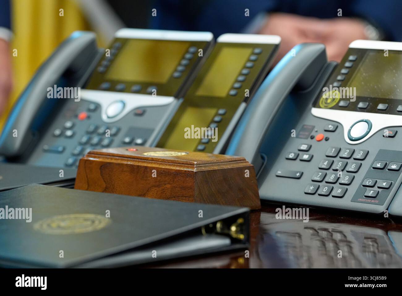 Phones on the Resolute Desk as President Donald Trump speaks in the ...