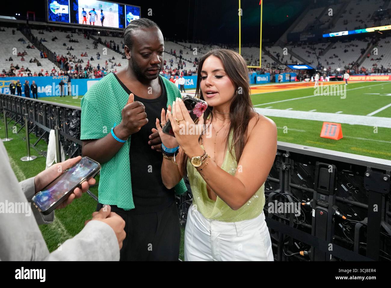 Koko DC, left, and Lucii LBA stand on the sideline before an NFL game ...