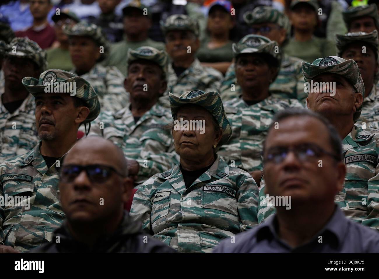 Members of the Bolivarian Militias listen to a recorded speech by ...