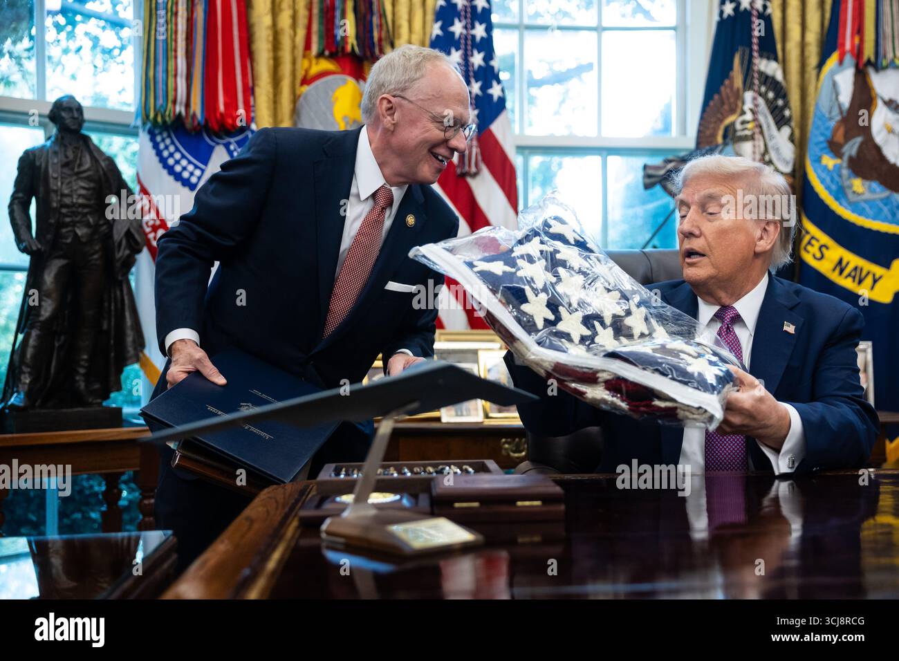 Rep. John Rose (R-Tenn.) presents a flag to President Donald Trump in ...