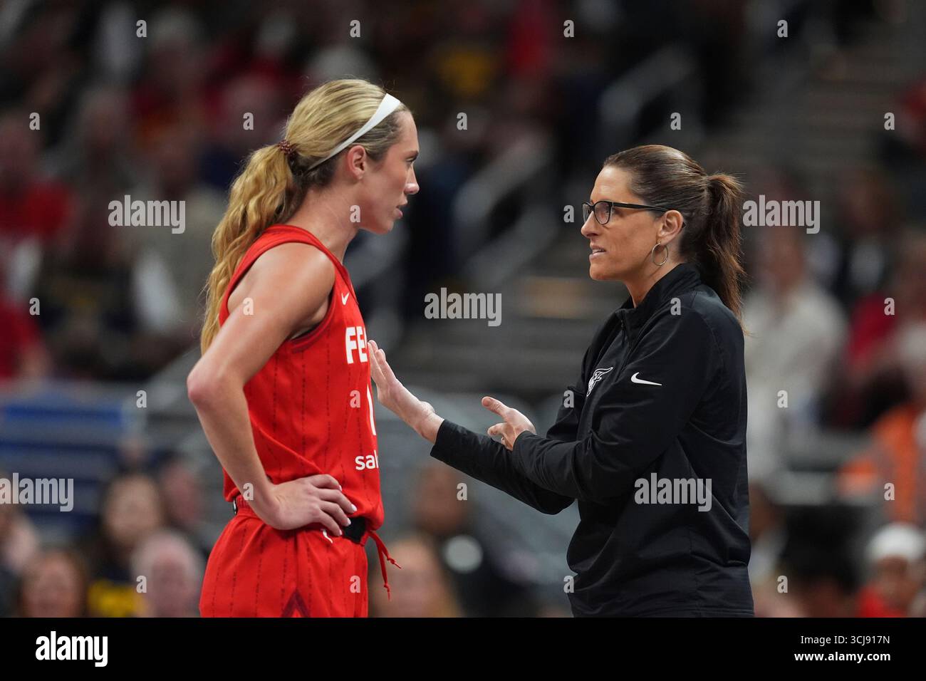 Indiana Fever head coach Stephanie White, right, talks with Lexie Hull, left, during the first ...