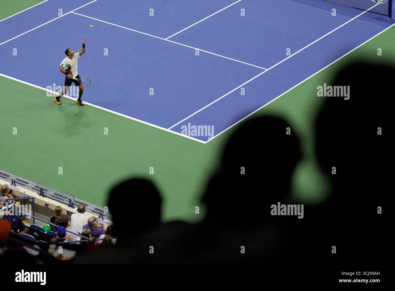Felix Auger-Aliassime, of Canada, serves to Jannik Sinner, of Italy ...