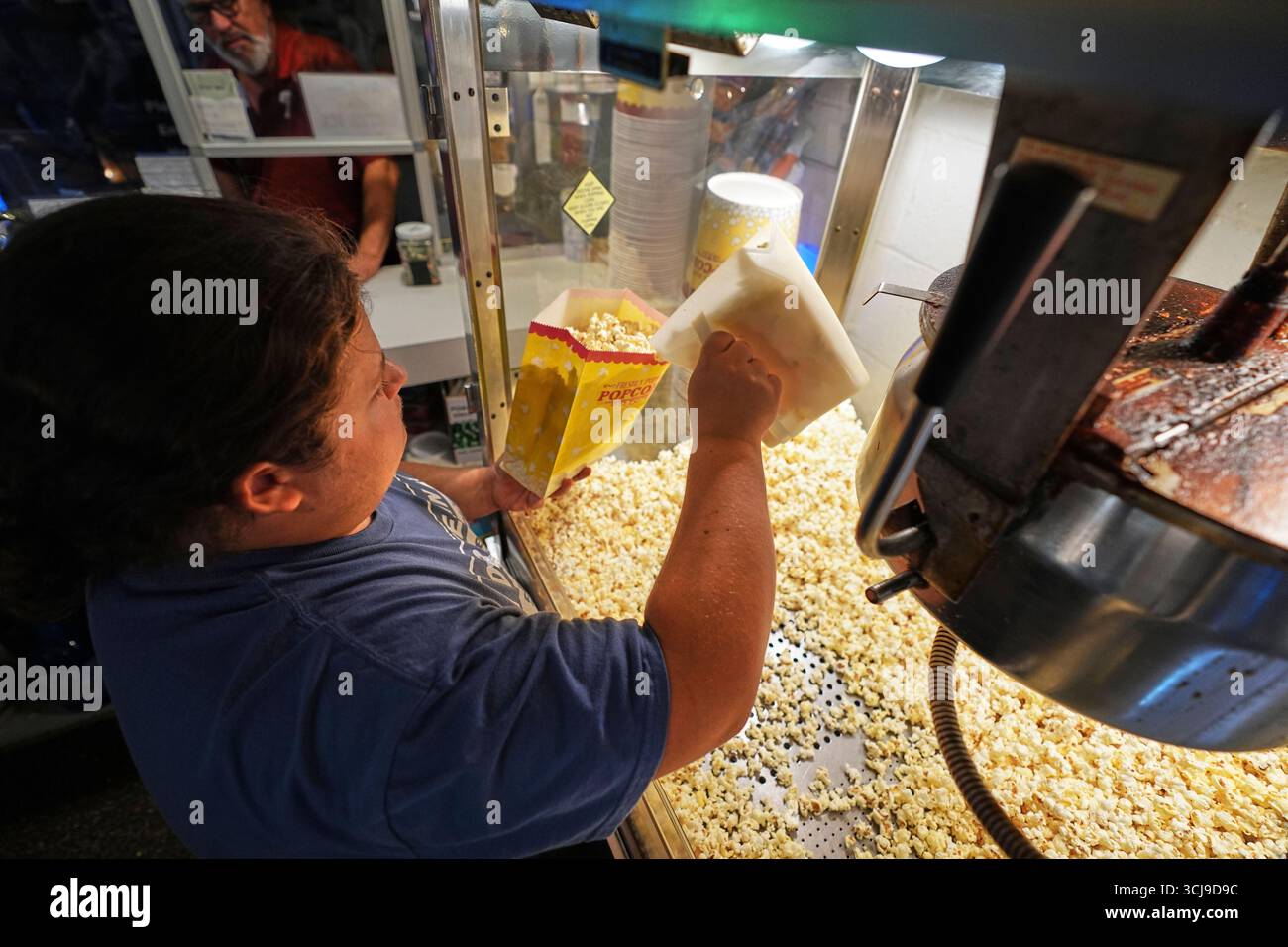 Mason Butz prepares a bag of popcorn in the refreshment stand at the ...
