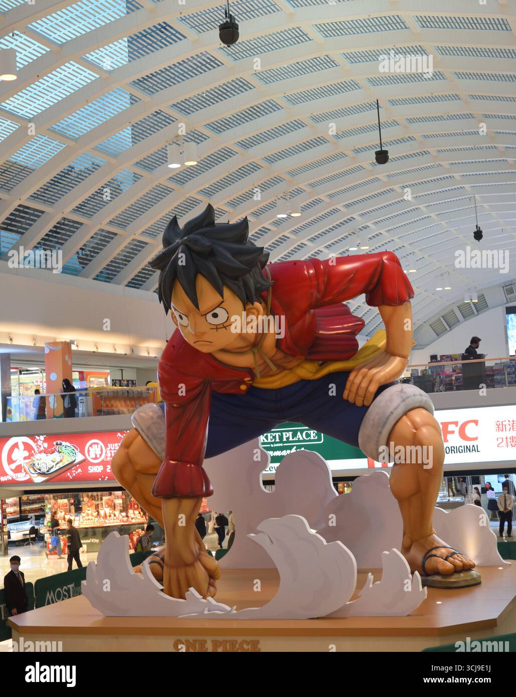 On podium inside a shopping arcade displays a large inflatable figure ...