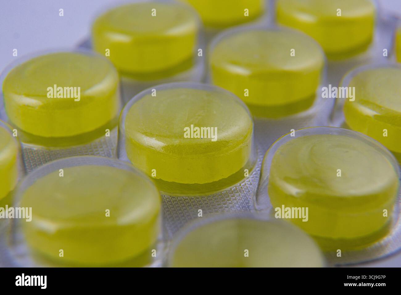 Yellow tablets are neatly arranged in a plastic blister pack ...