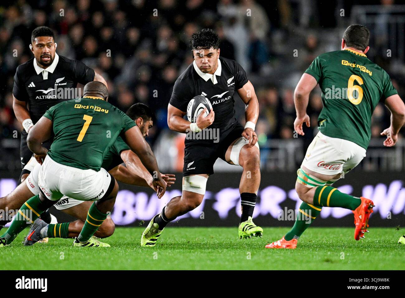 Wallace Sititi, centre, of New Zealand runs at the defence during their ...