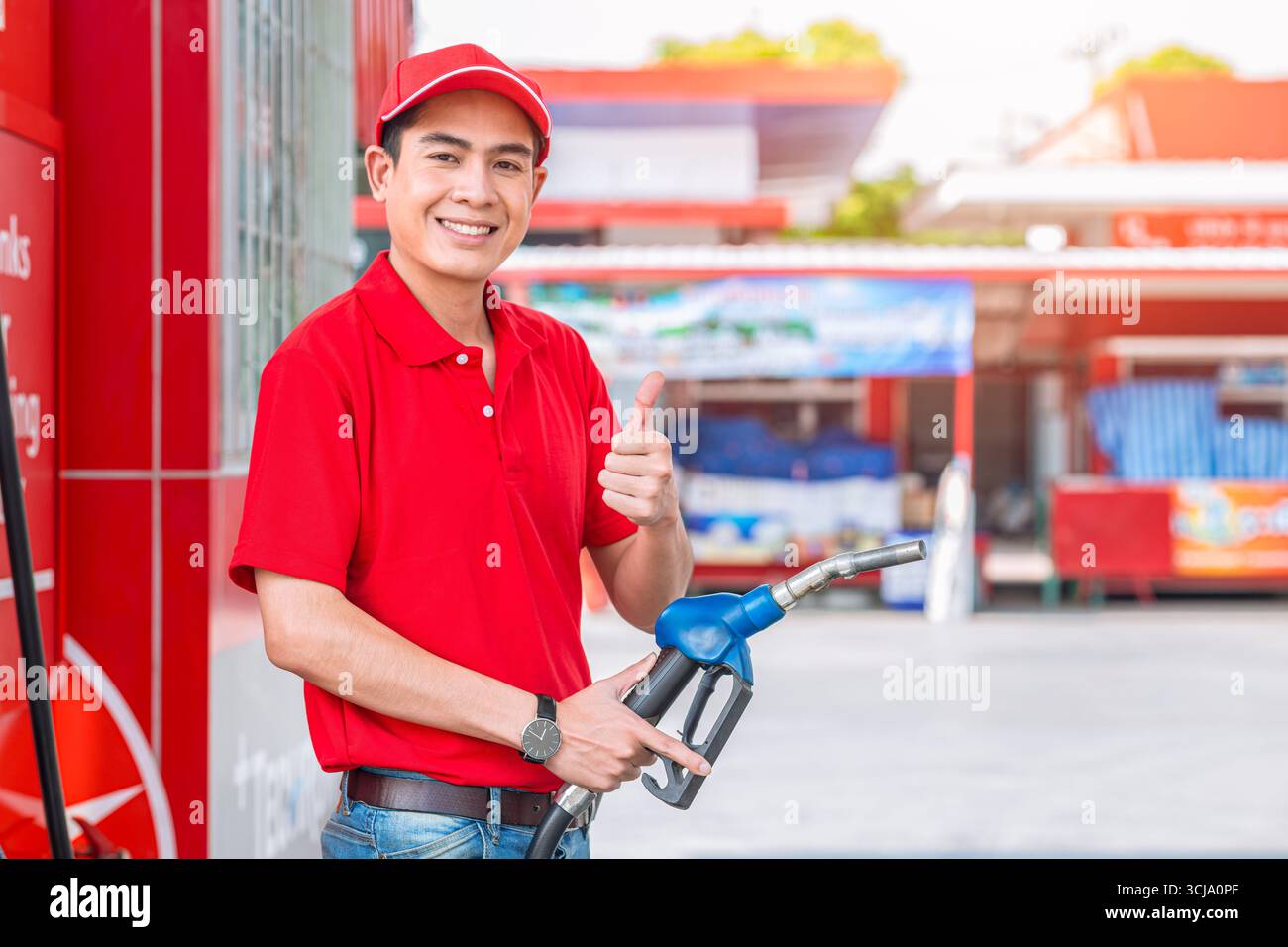 Happy gas station staff worker asian male hand holding fuel nozzle for ...