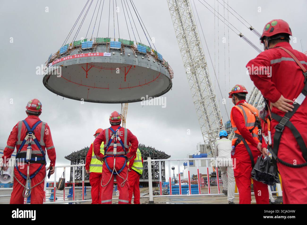 Workers install the dome of the containment vessel of Unit 4 at the ...