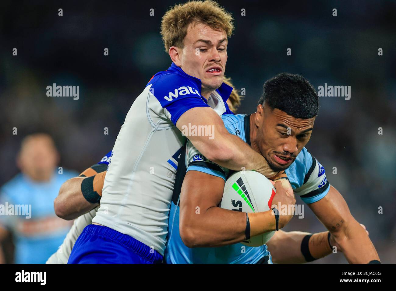 Ronaldo Mulitalo of the Sharks is tackled by Lachlan Galvin of the ...