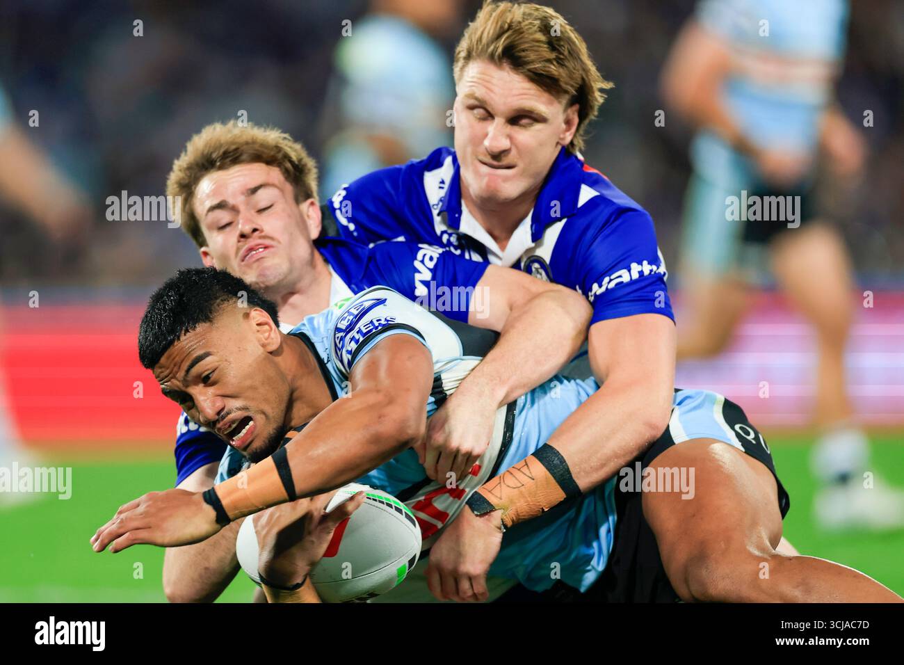 Ronaldo Mulitalo of the Sharks is tackled by Lachlan Galvin of the ...