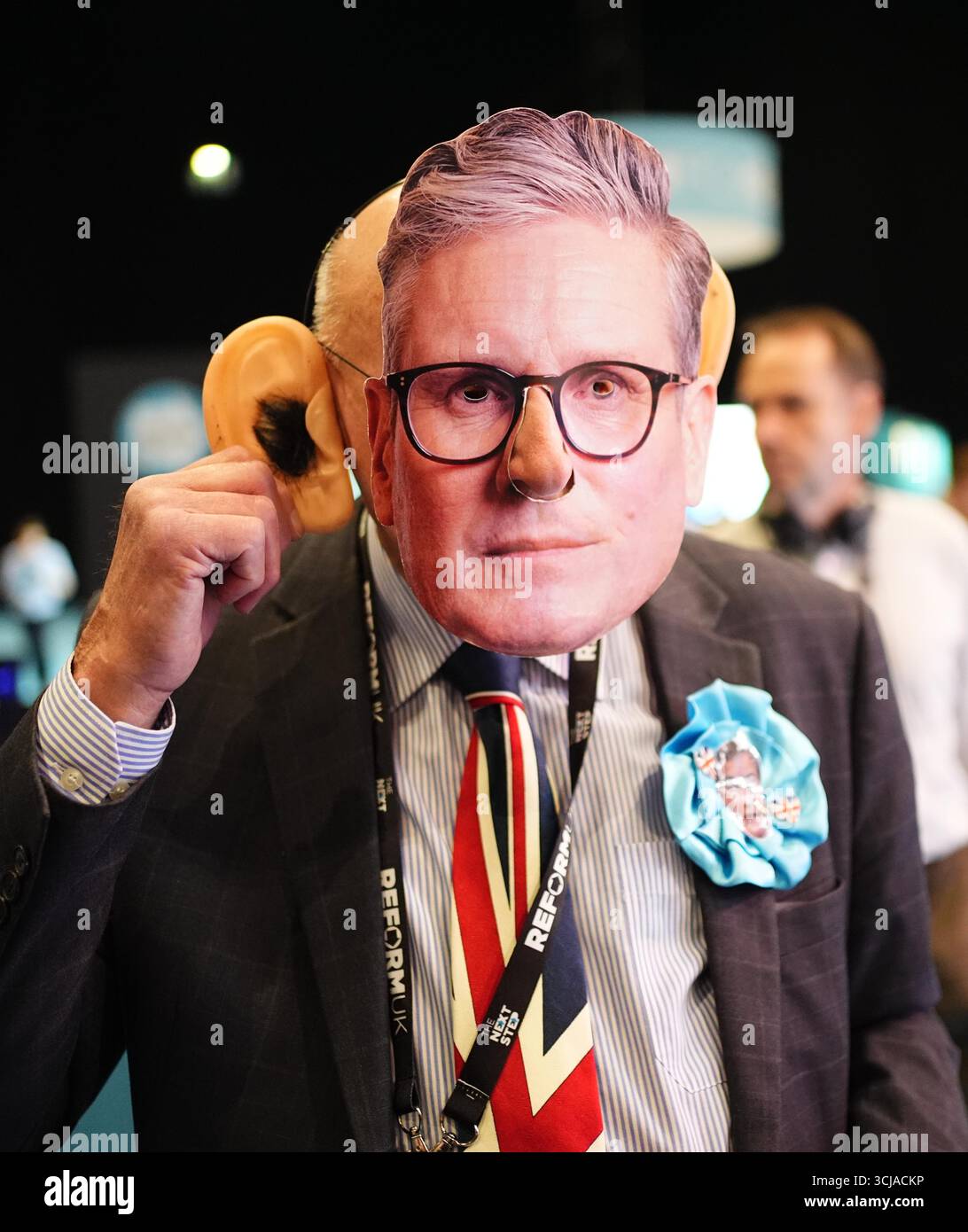 A Reform UK supporter wearing a Sir Keir Starmer mask during the party ...