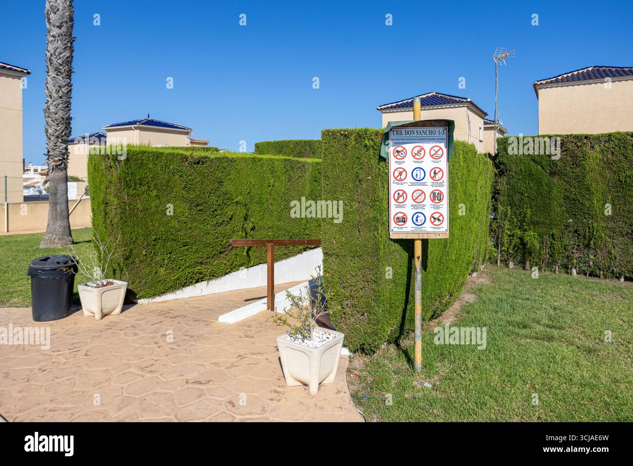 Gated entrance to community pool area with pathway, green hedges, and ...
