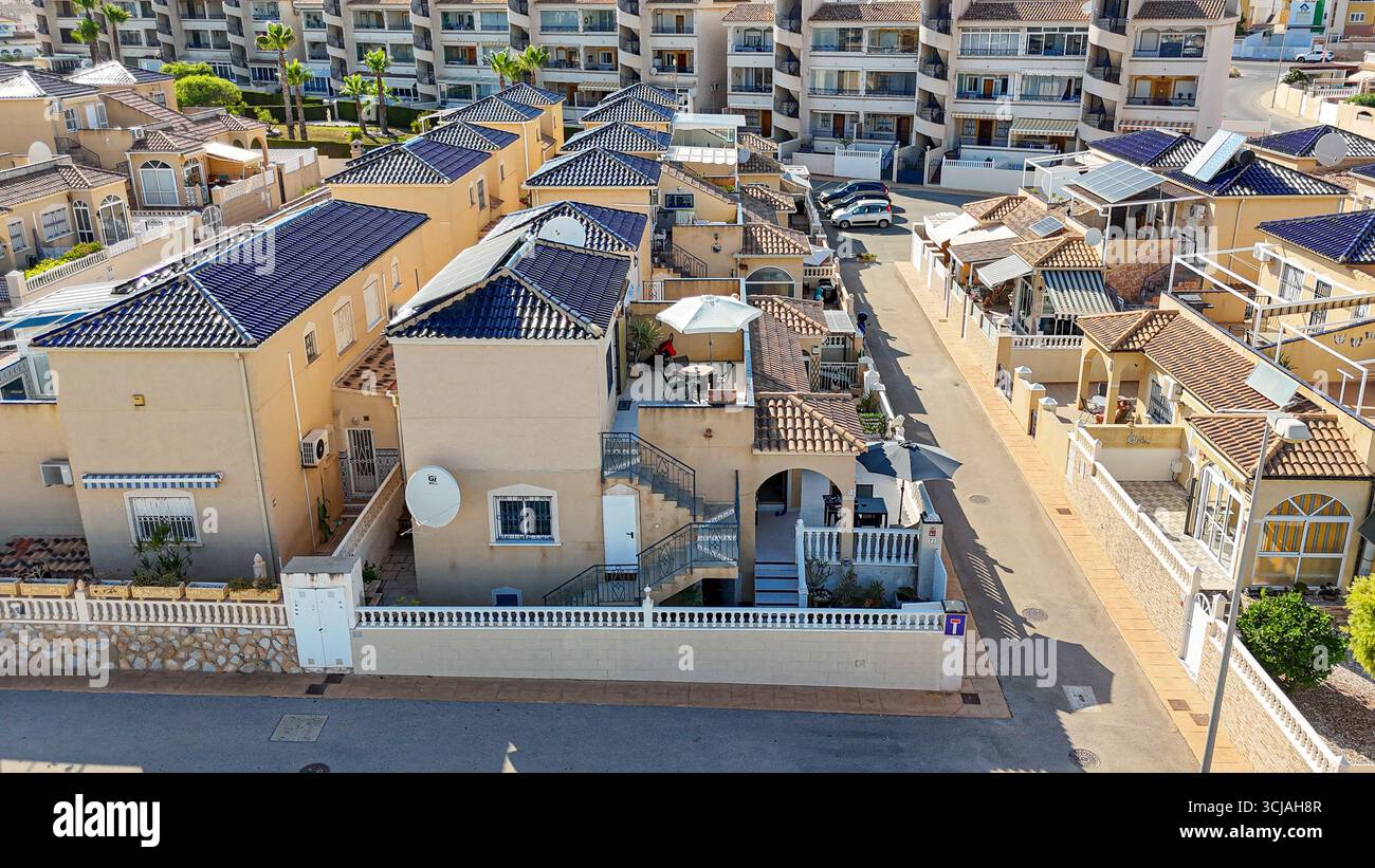 Ground-level view of houses with terraces, umbrellas, and solar panels ...