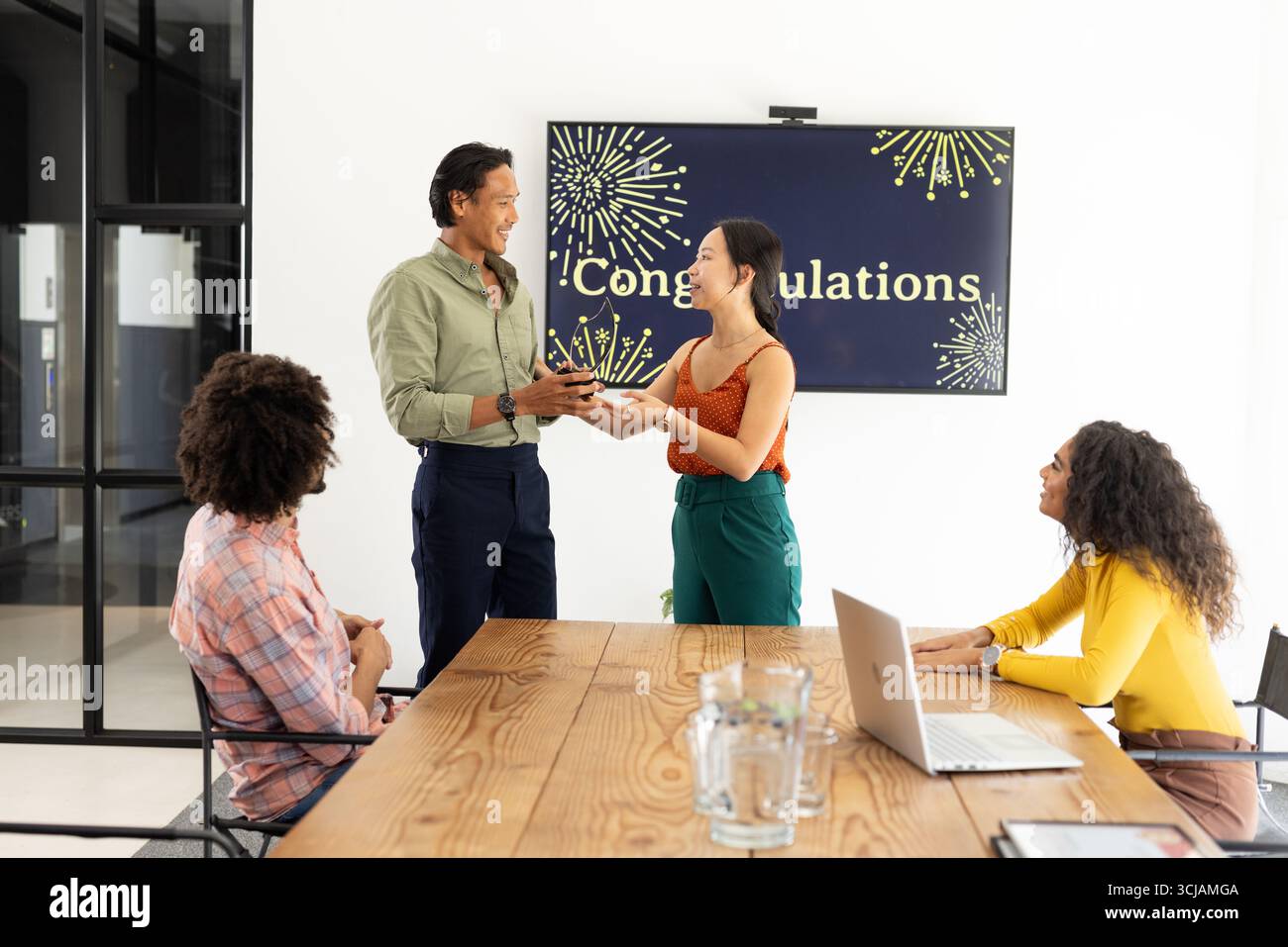 Celebrating achievement colleagues presenting hi-res stock photography ...