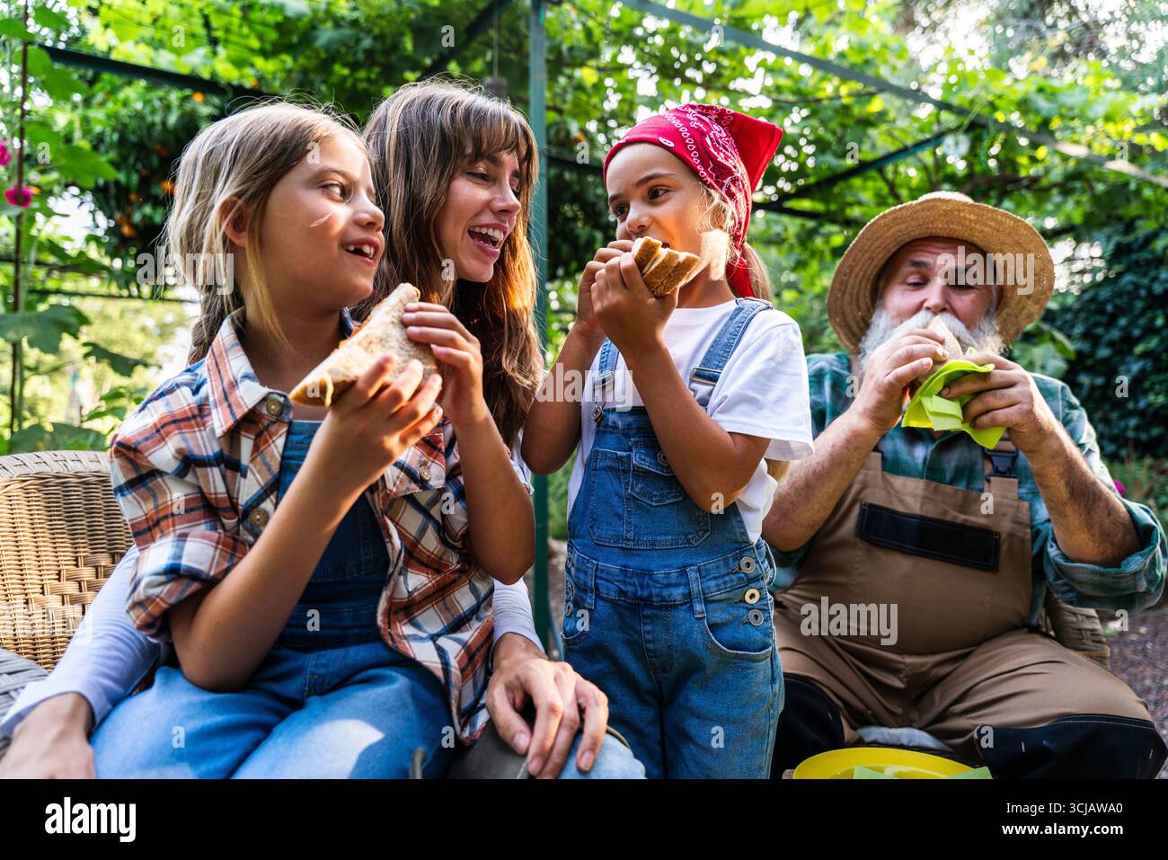 Mother with her daughters and grandfather enjoying a healthy sandwich ...