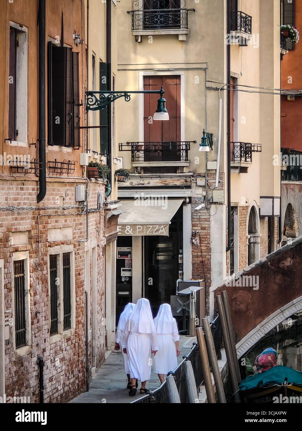 A street-level shot in Venice, highlighting a group of individuals ...
